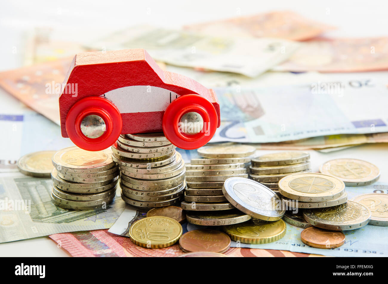 red toy car on banknotes and coins Stock Photo - Alamy