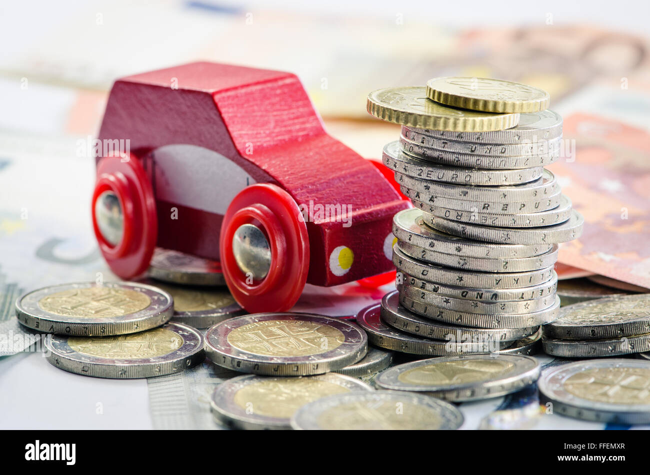 red toy car and pile of coins Stock Photo - Alamy