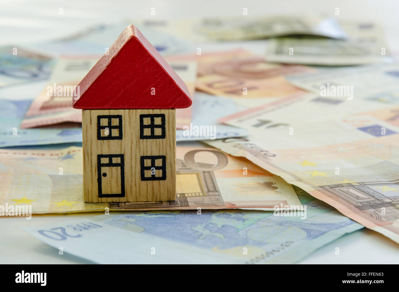 wooden toy house, banknotes and coins Stock Photo - Alamy