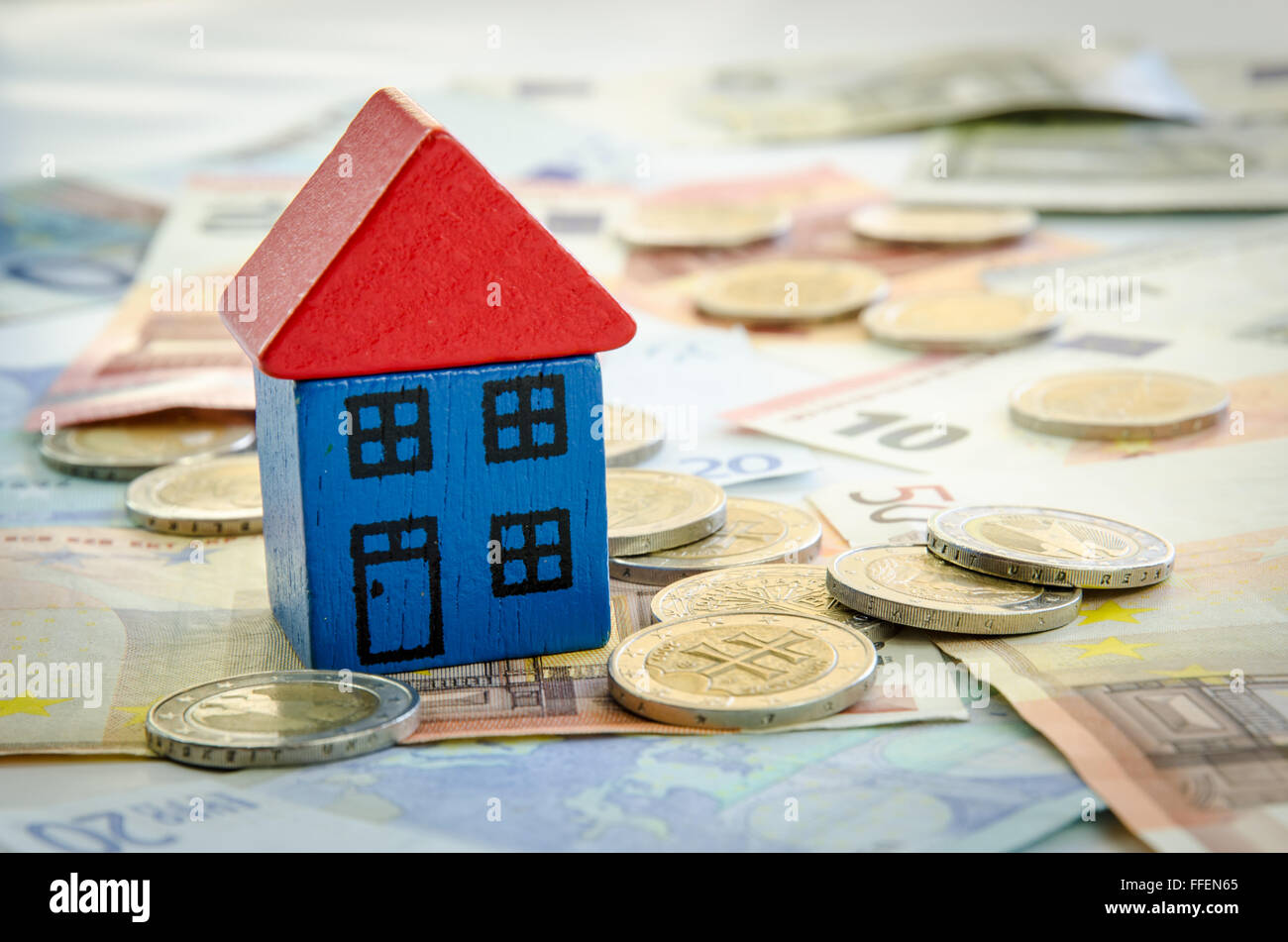 wooden toy house, banknotes and coins Stock Photo - Alamy