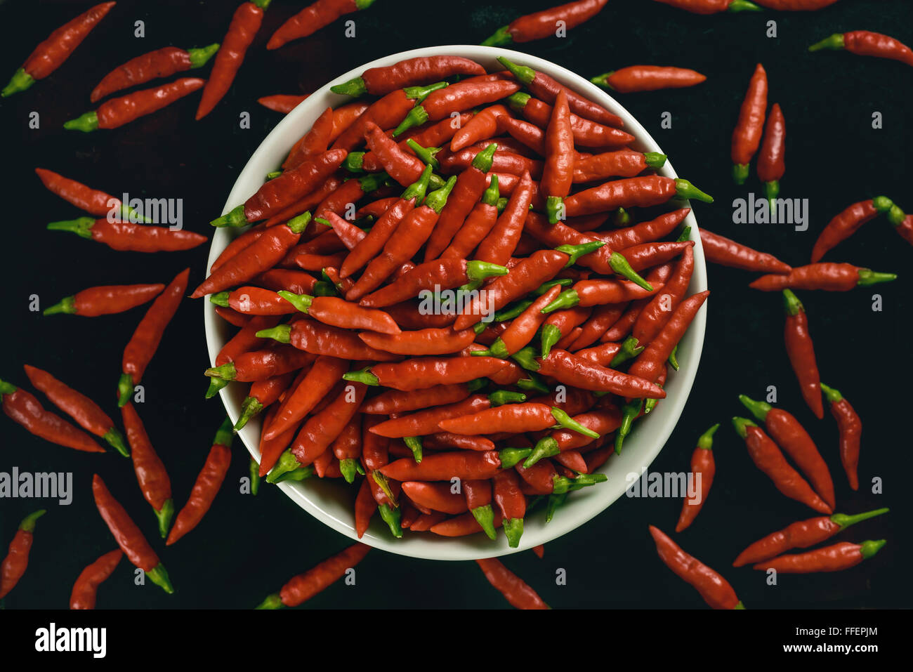 Red pepper in bowl on black background Stock Photo - Alamy