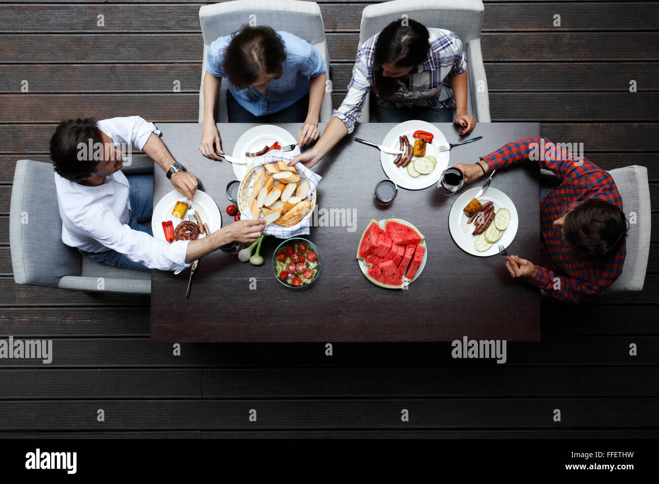 Four friends having dinner, top view Stock Photo - Alamy