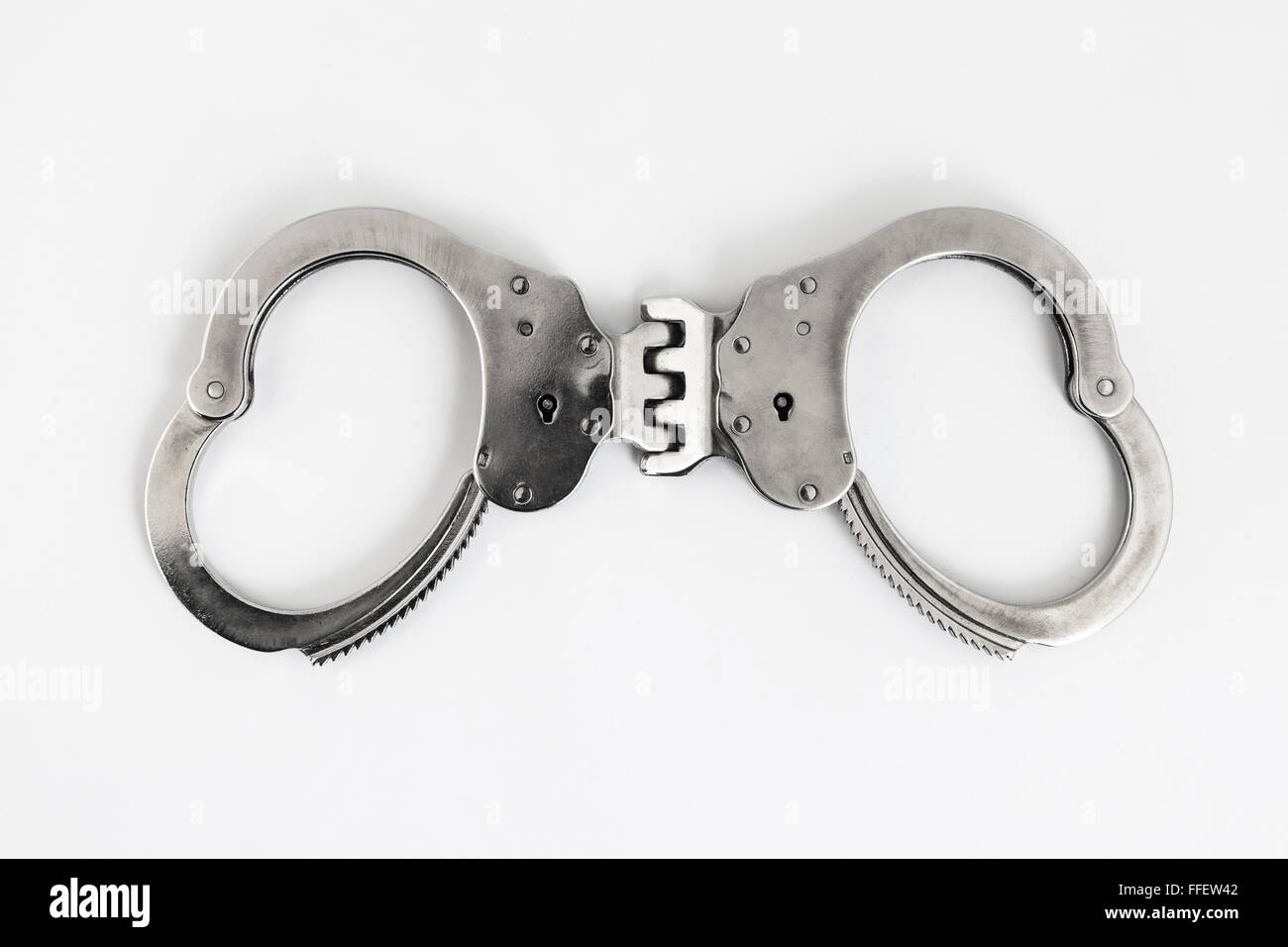 closed handcuffs with white background Stock Photo - Alamy
