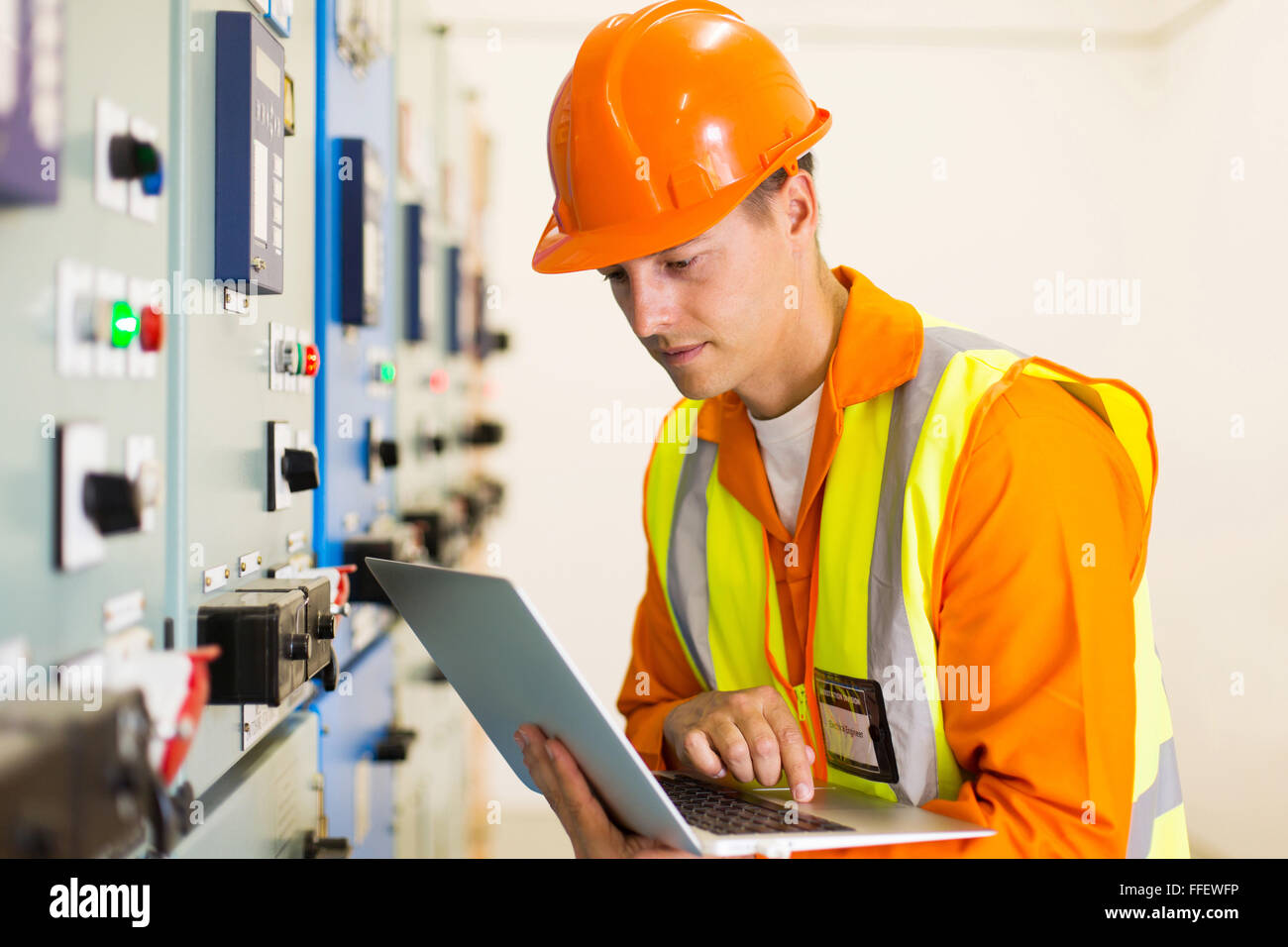 electrician working on laptop computer in control room Stock Photo - Alamy