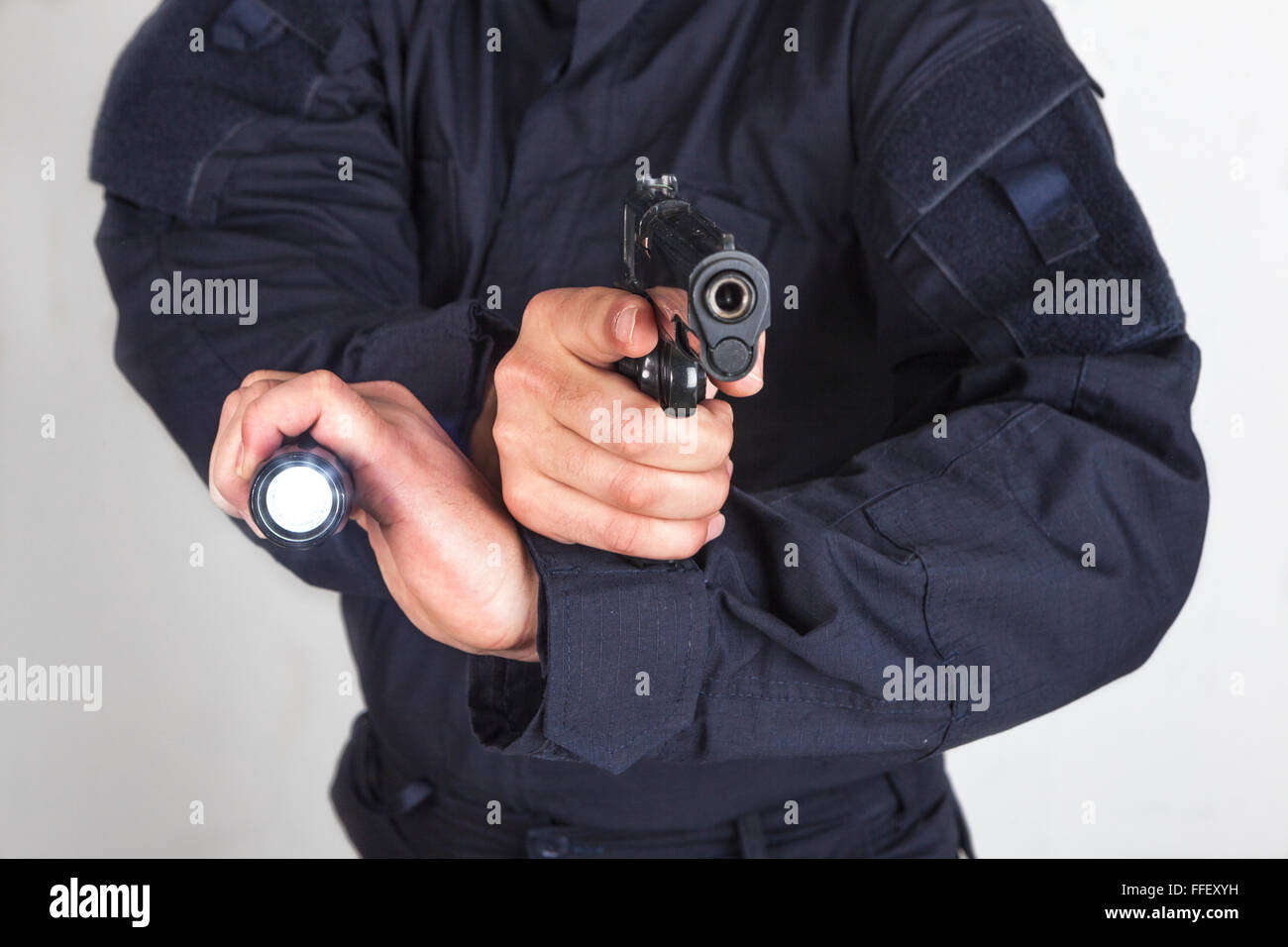 Policeman with gun and flashlight Stock Photo - Alamy