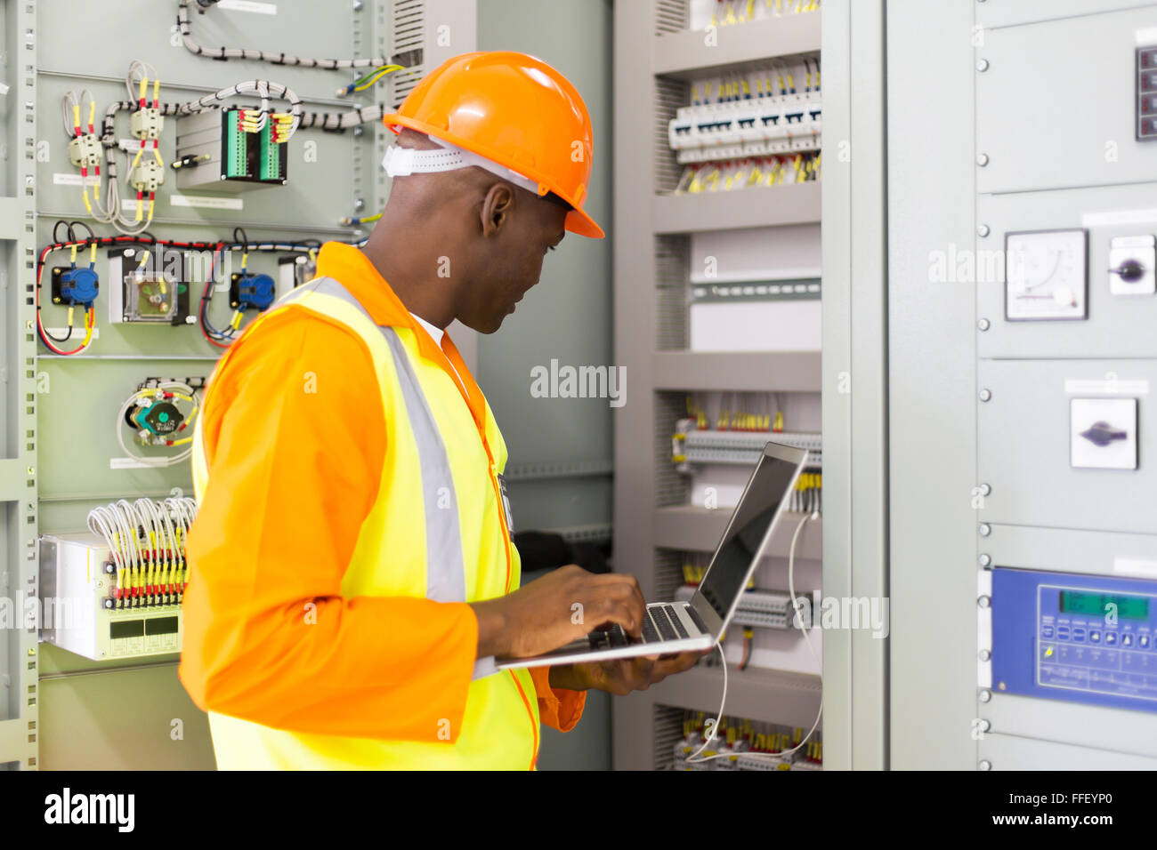 African American industrial engineer checking computerized machine ...