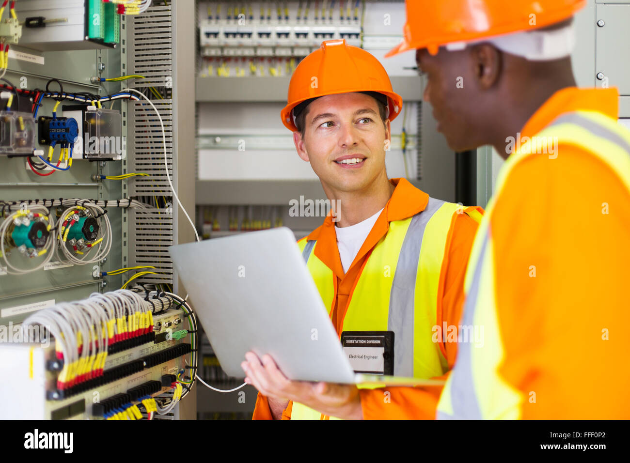 electrical engineers adjusting transformer settings in control room ...