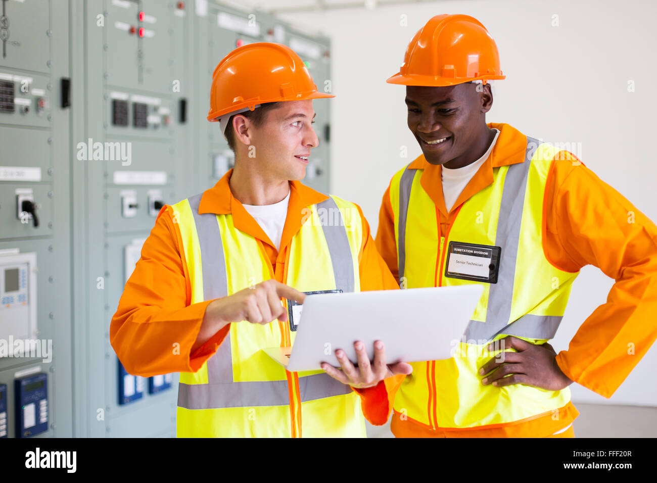 professional male technicians using laptop in control room Stock Photo ...