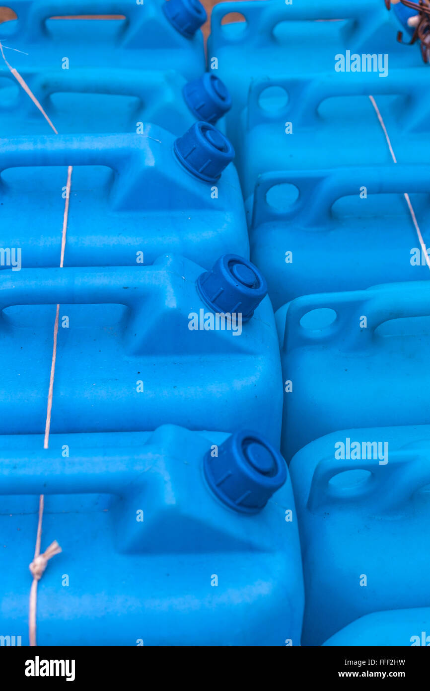 Blue plastic gas cans (fuel container) in an open market under natural ...
