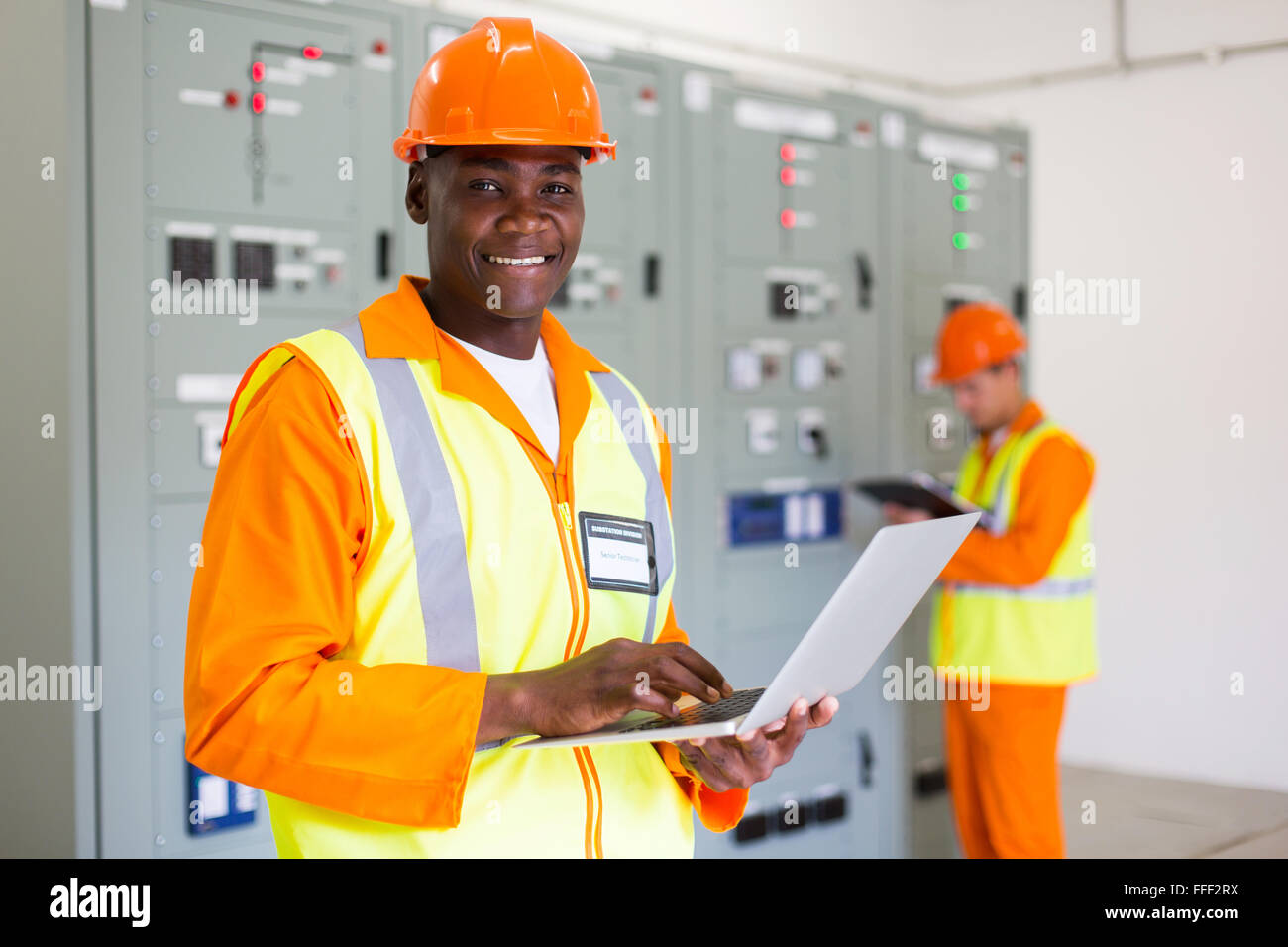 professional senior afro American control room technician using laptop ...