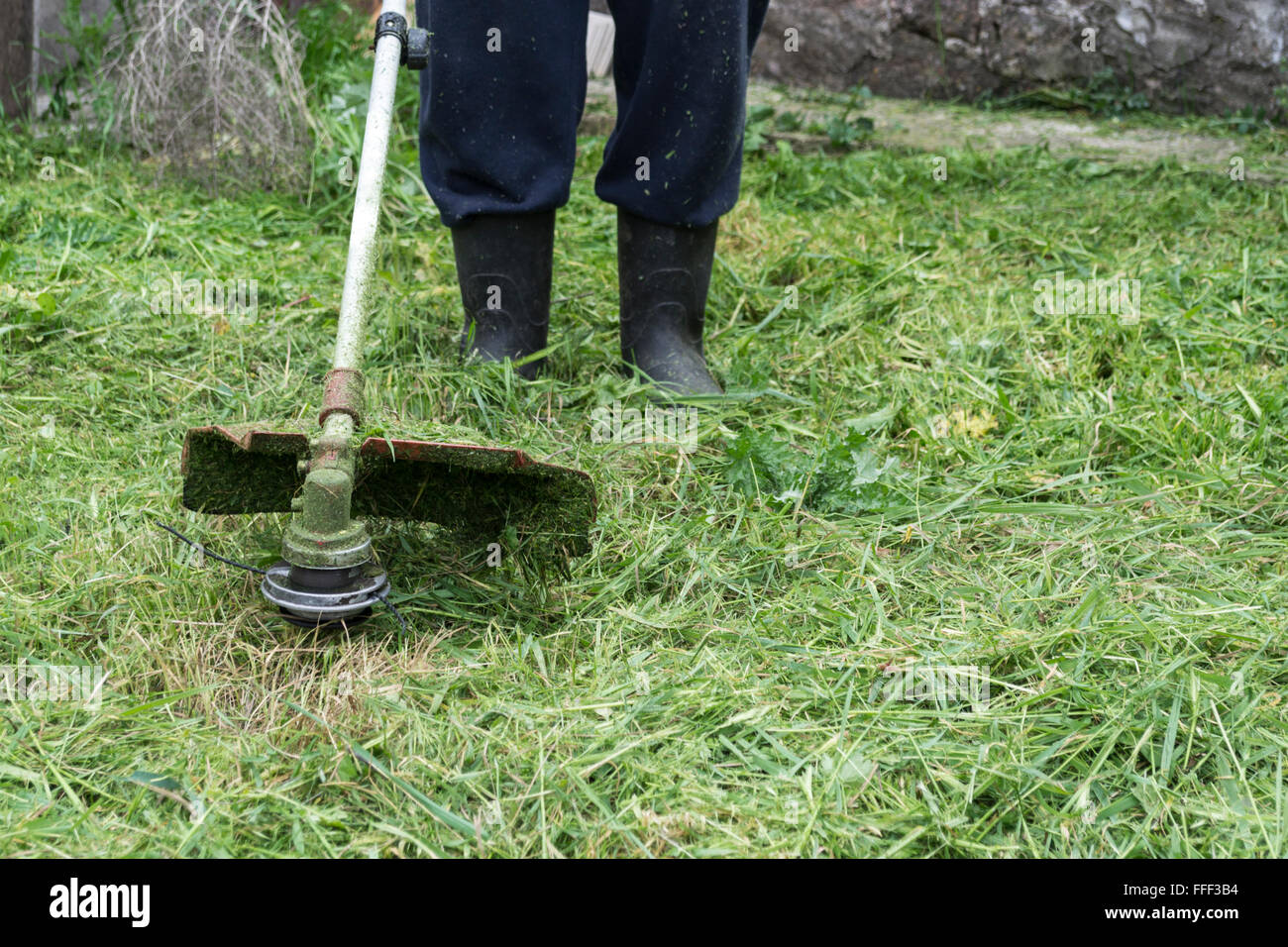 Man working with a lawn mower trimmer Stock Photo - Alamy