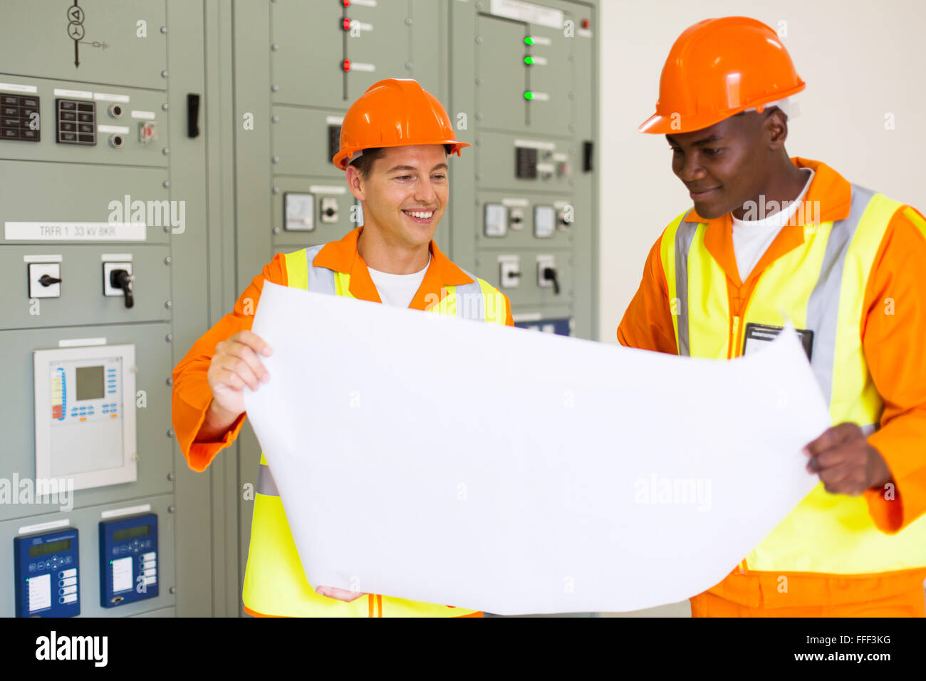 successful power company technical co-workers holding blueprint in ...