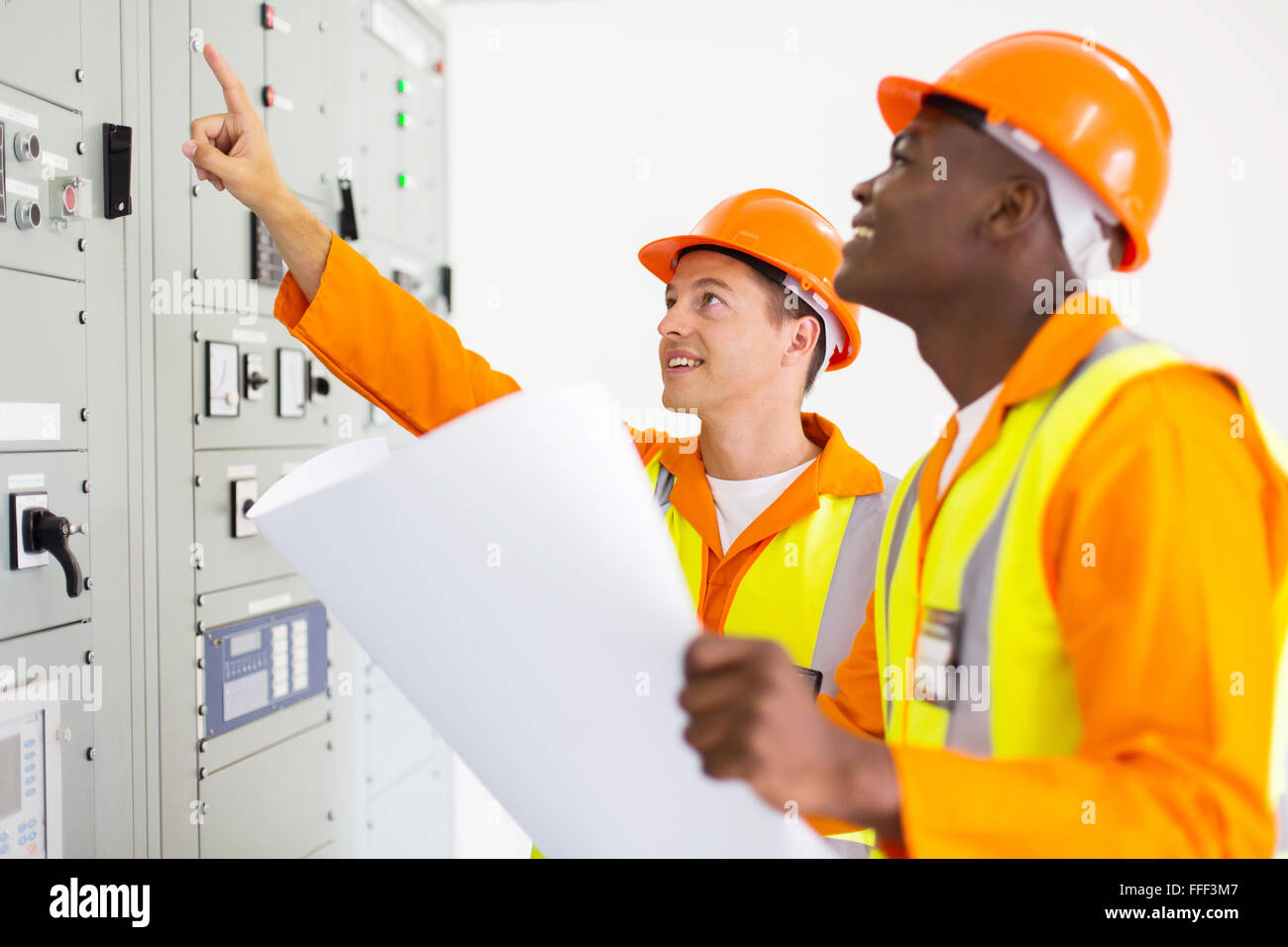 professional electricians working together in control room Stock Photo ...