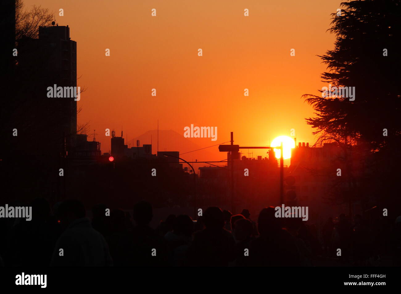 People watch the sun set behind Mount Fuji from Tokyo's Jingu Gaien ...