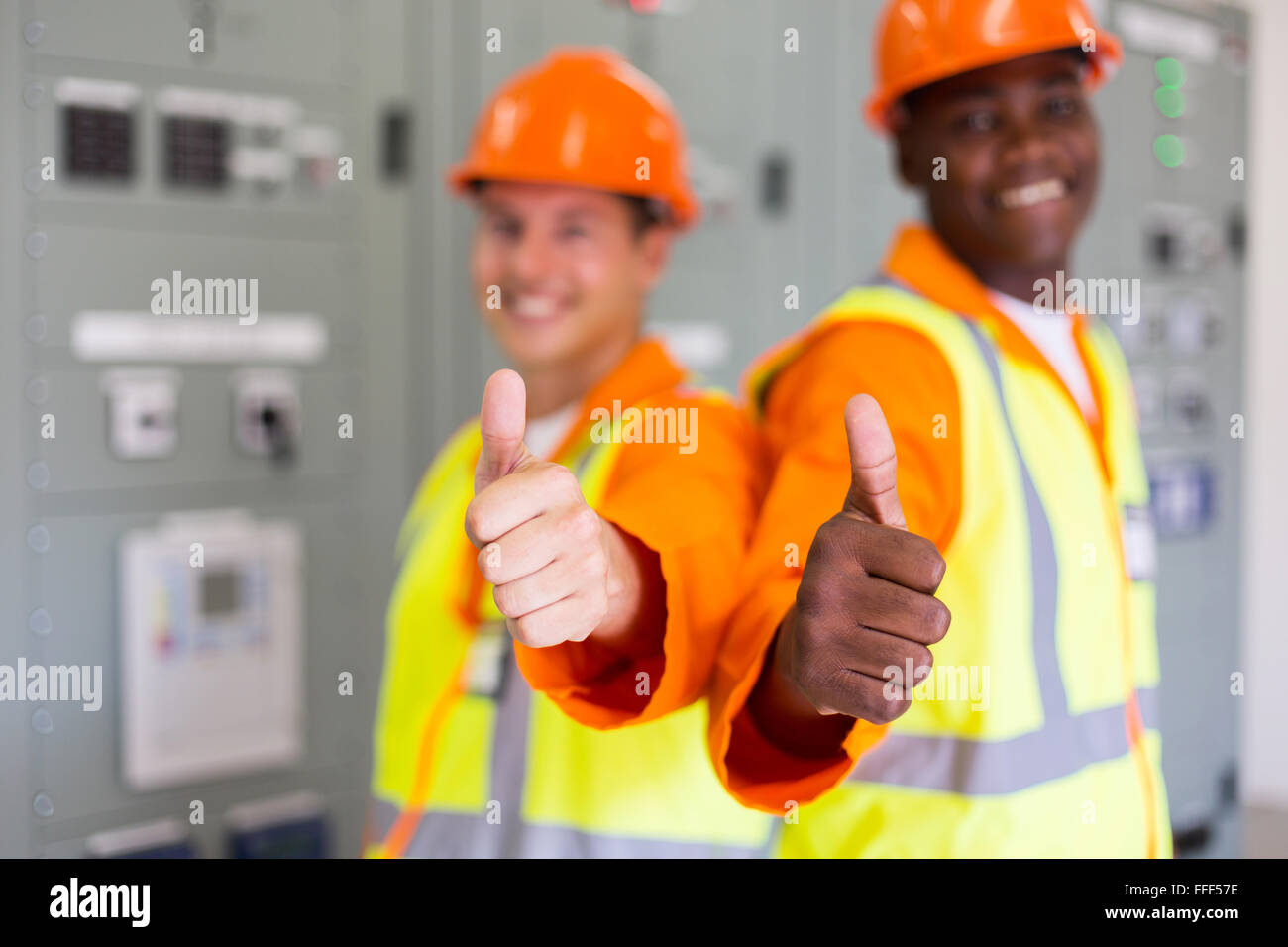 happy multiracial electrical co-workers thumbs up Stock Photo - Alamy