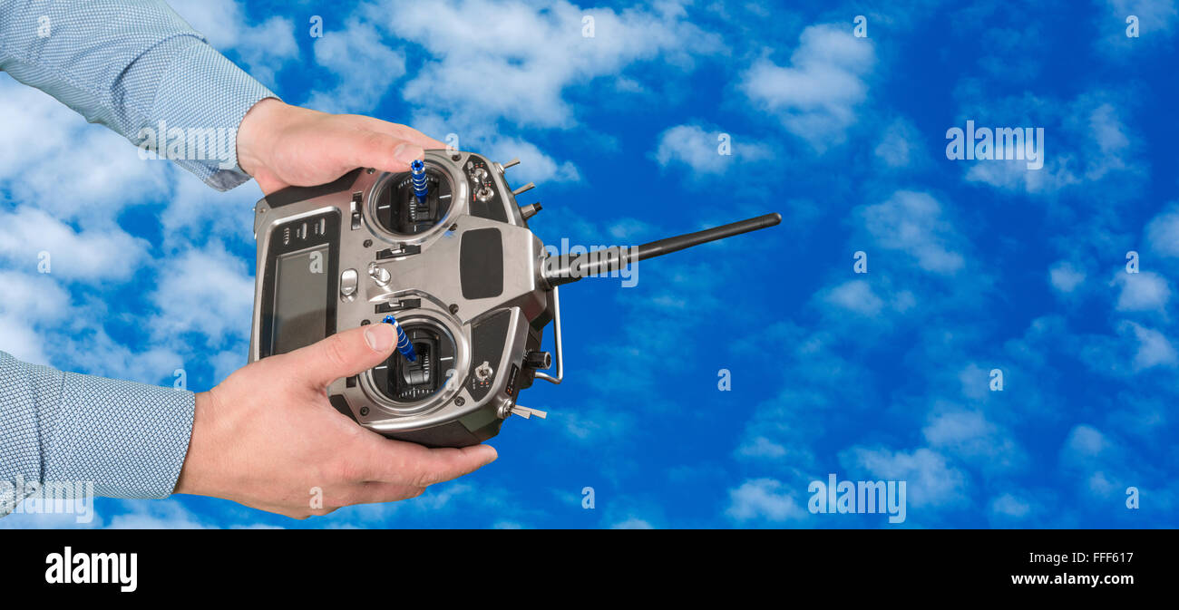 Flight remote controller in man's hands close up view on blue sky ...