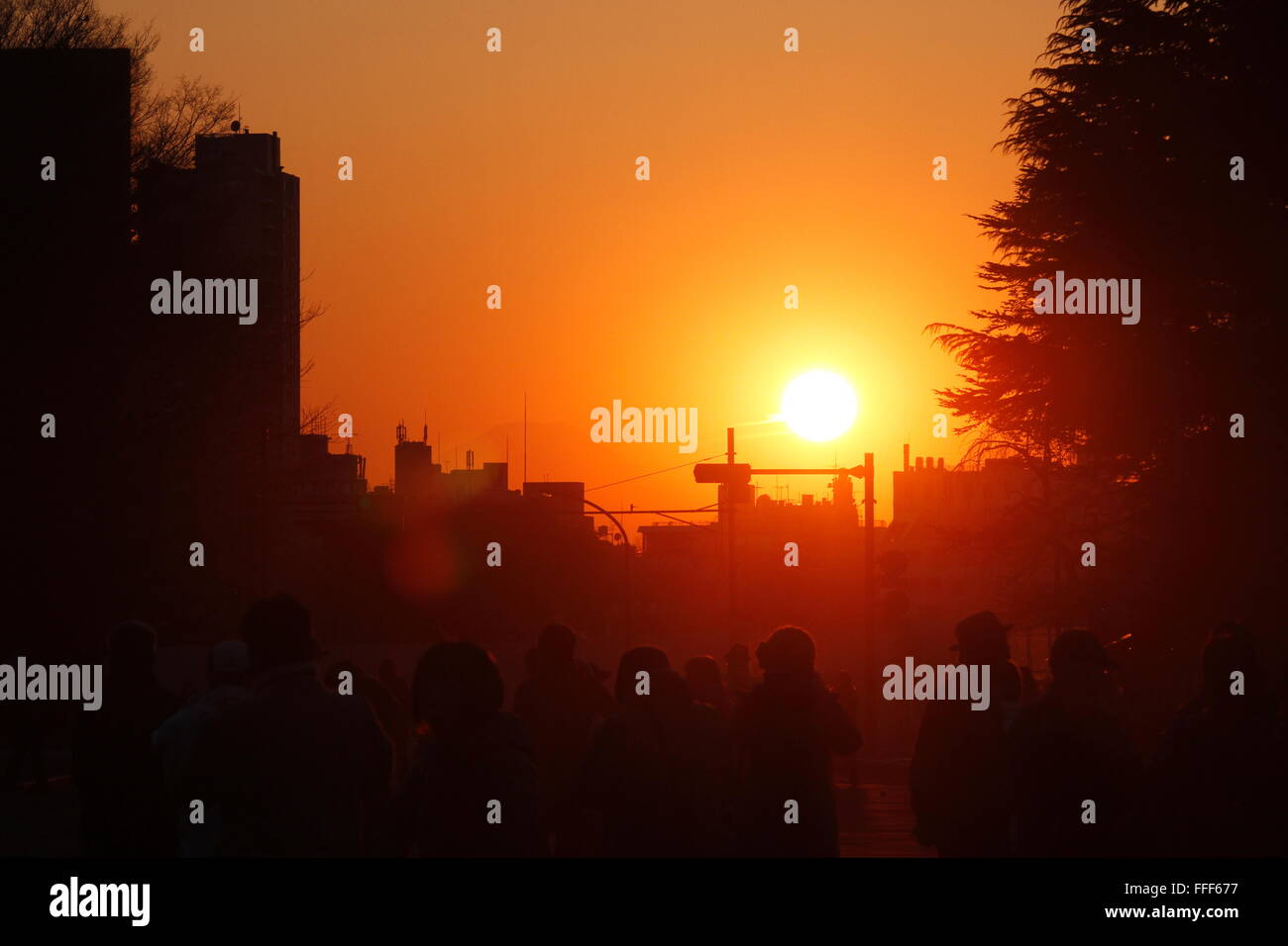 People watch the sun set behind Mount Fuji from Tokyo's Jingu Gaien ...
