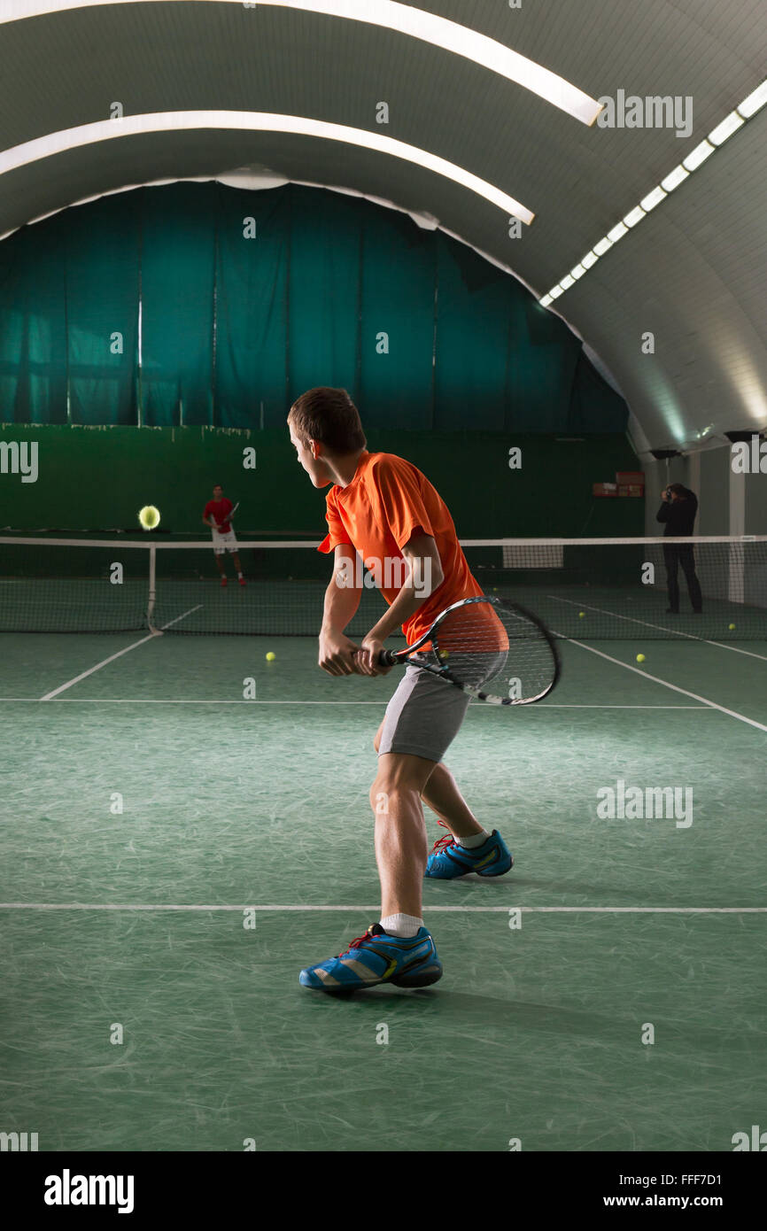 Young tennis player kicking the ball at the training Stock Photo - Alamy