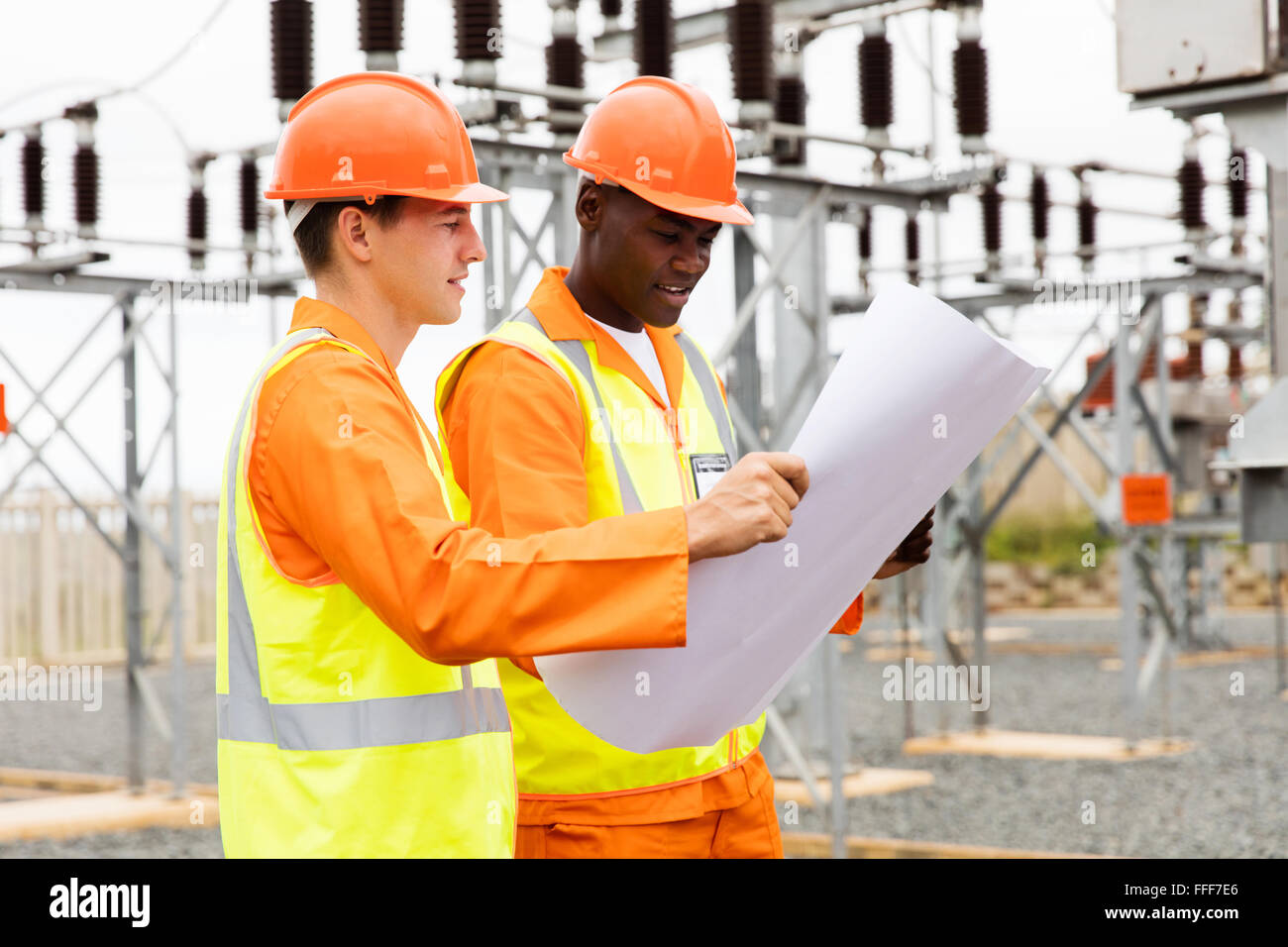 electric engineers discussing blueprint in substation Stock Photo - Alamy