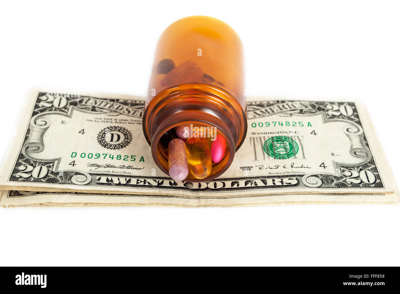 Open bottle of pills on a pile of money dollars Stock Photo - Alamy