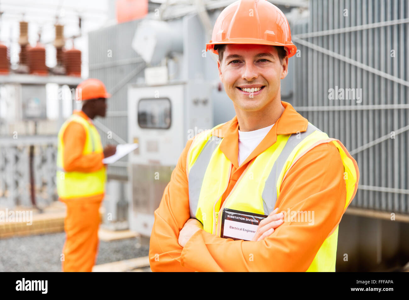 close up portrait of young electrical engineer with arms crossed in ...