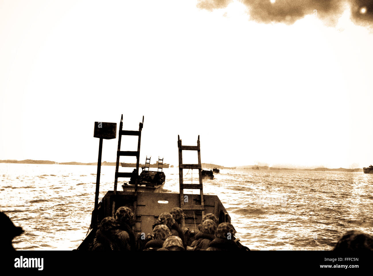 Carrying scaling ladders, U.S. Marines in landing crafts head for the ...