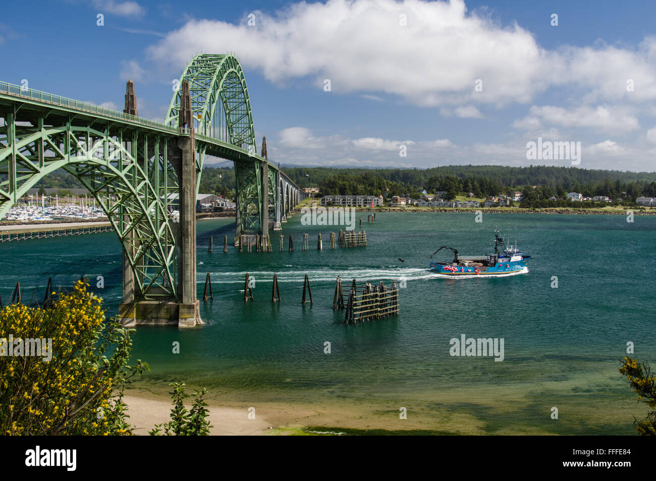 Yaquina Bay Bridge with fishing boat heading out to sea, Newport ...