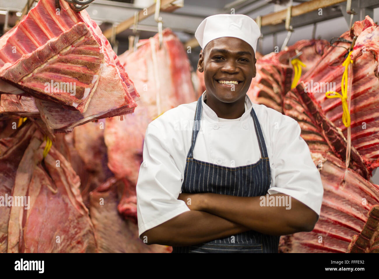 smiling African butcher standing in meat storeroom Stock Photo - Alamy