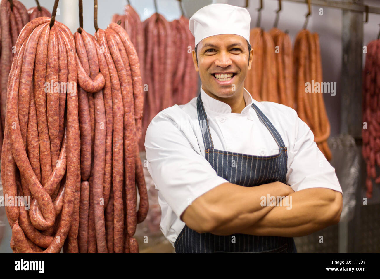 portrait of mid age butcher with arms crossed in butchery Stock Photo ...