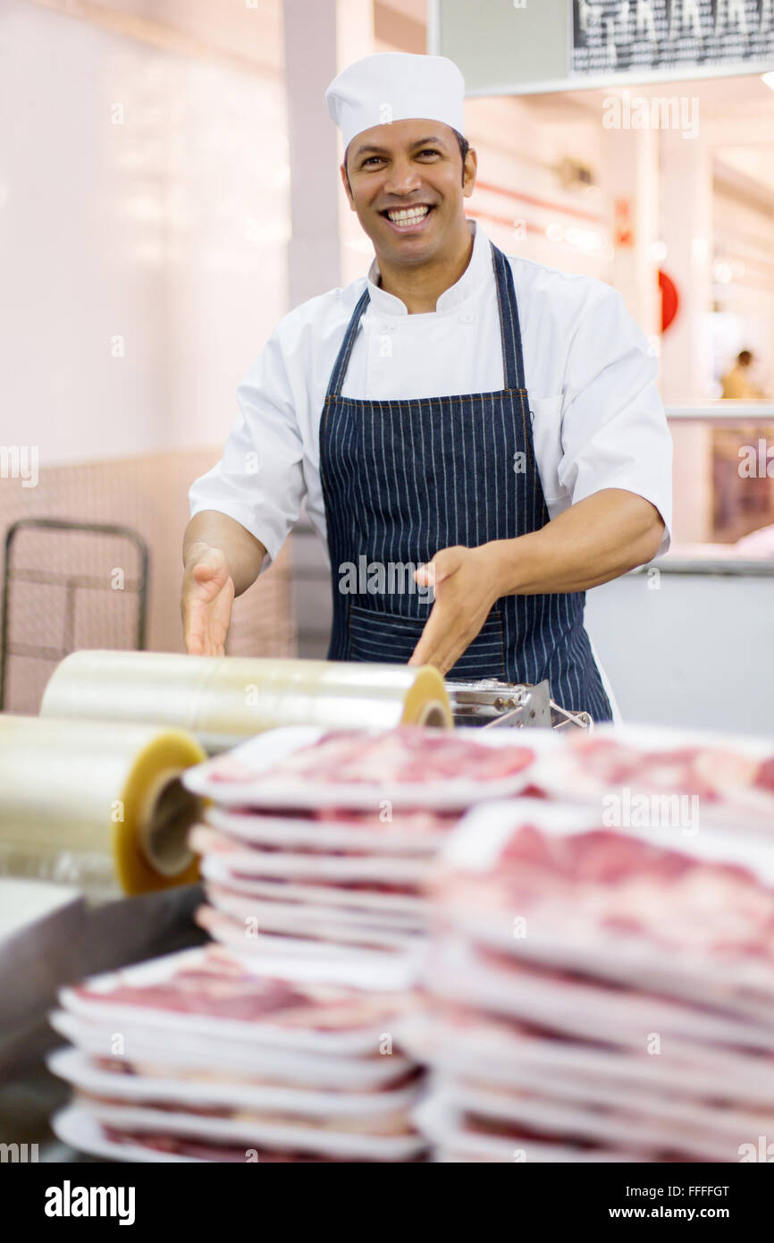 happy male butcher wrapping meat in butchery Stock Photo - Alamy