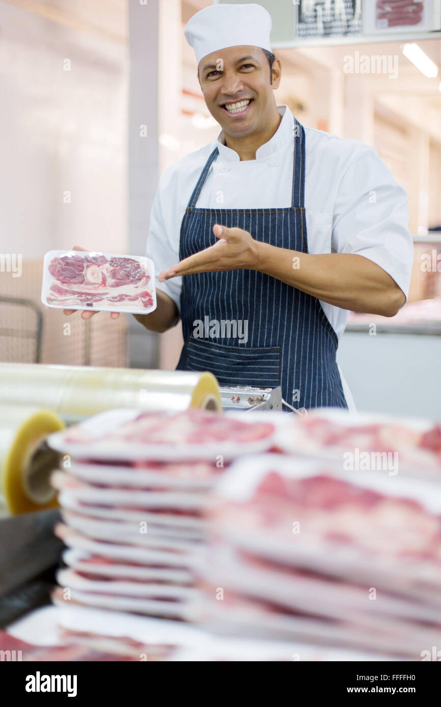 cheerful middle aged butcher presenting fresh meat Stock Photo - Alamy