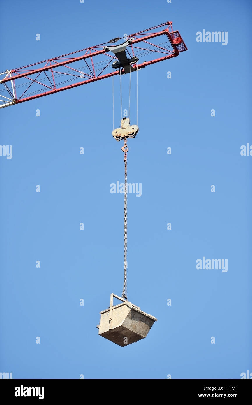 Detail shot with a construction crane loading a industrial container ...