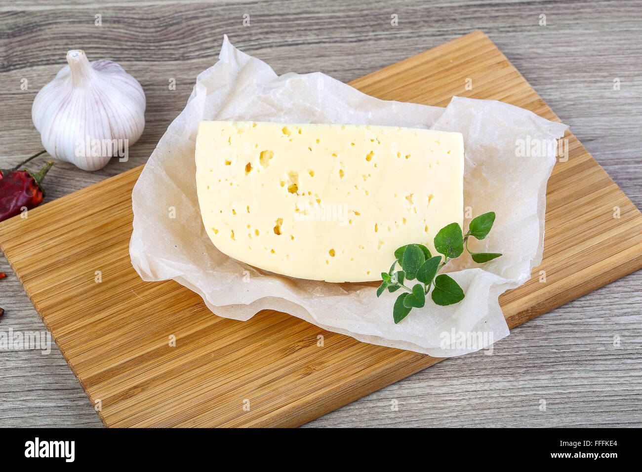 Part of round cheese on the wood background with herbs Stock Photo - Alamy