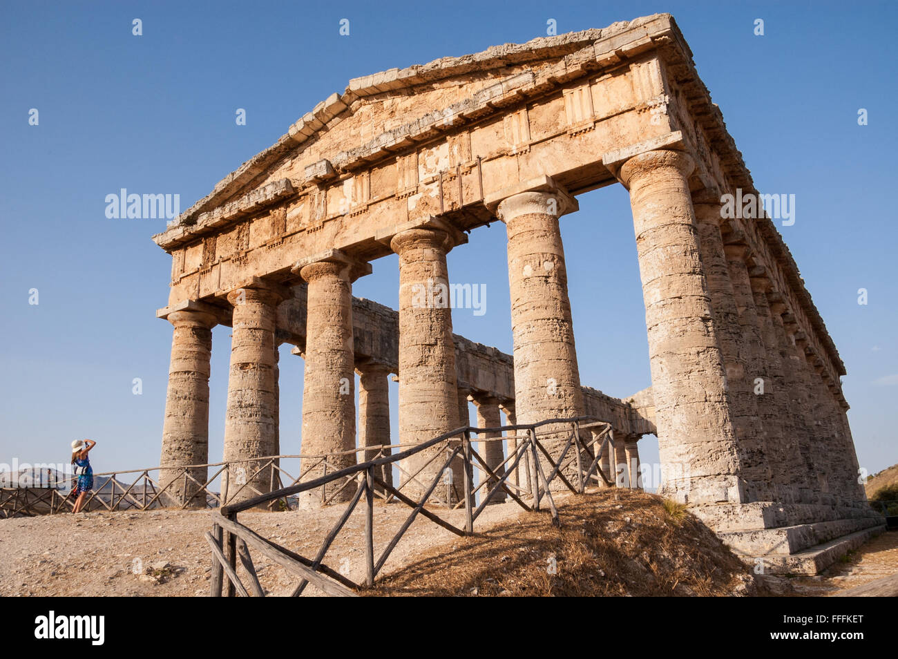 Ancient Greek temple with a tourist taking a picture in front of it ...