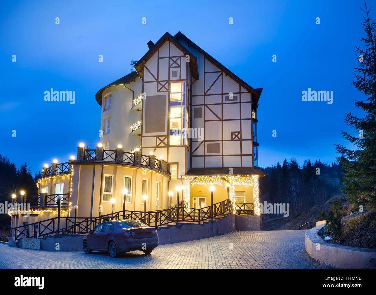Illuminated house in the forest at sunset Stock Photo - Alamy