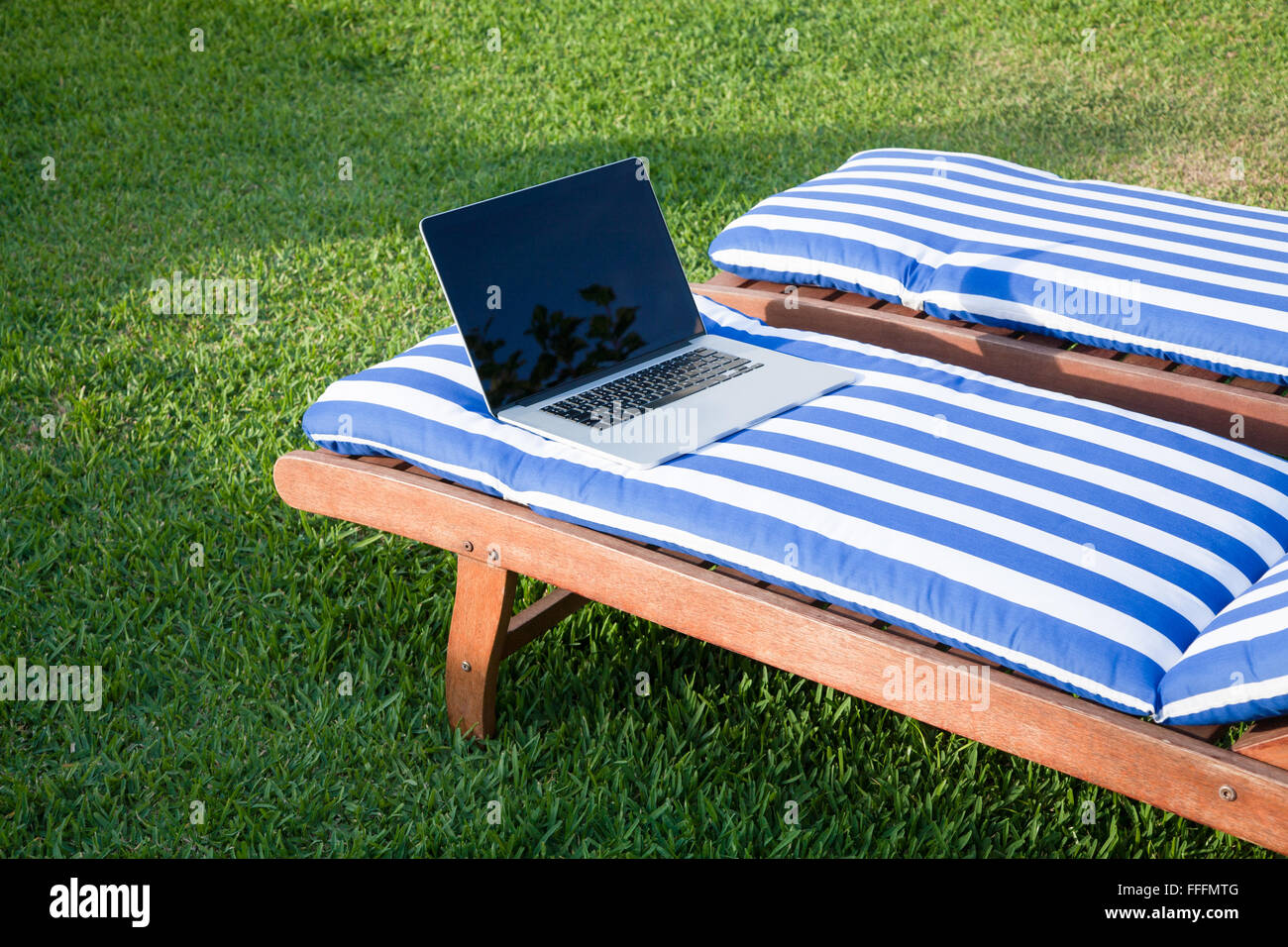 grey laptop computer open with keyboard on white and blue striped mat ...