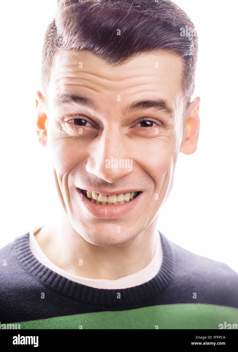 Portrait of a smart serious young man standing against white background ...