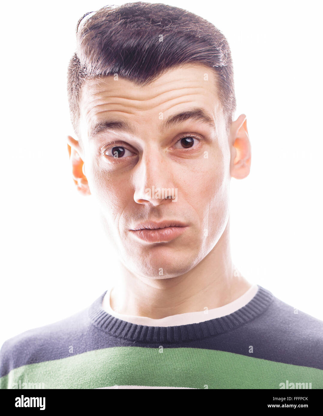 Portrait of a smart serious young man standing against white background ...