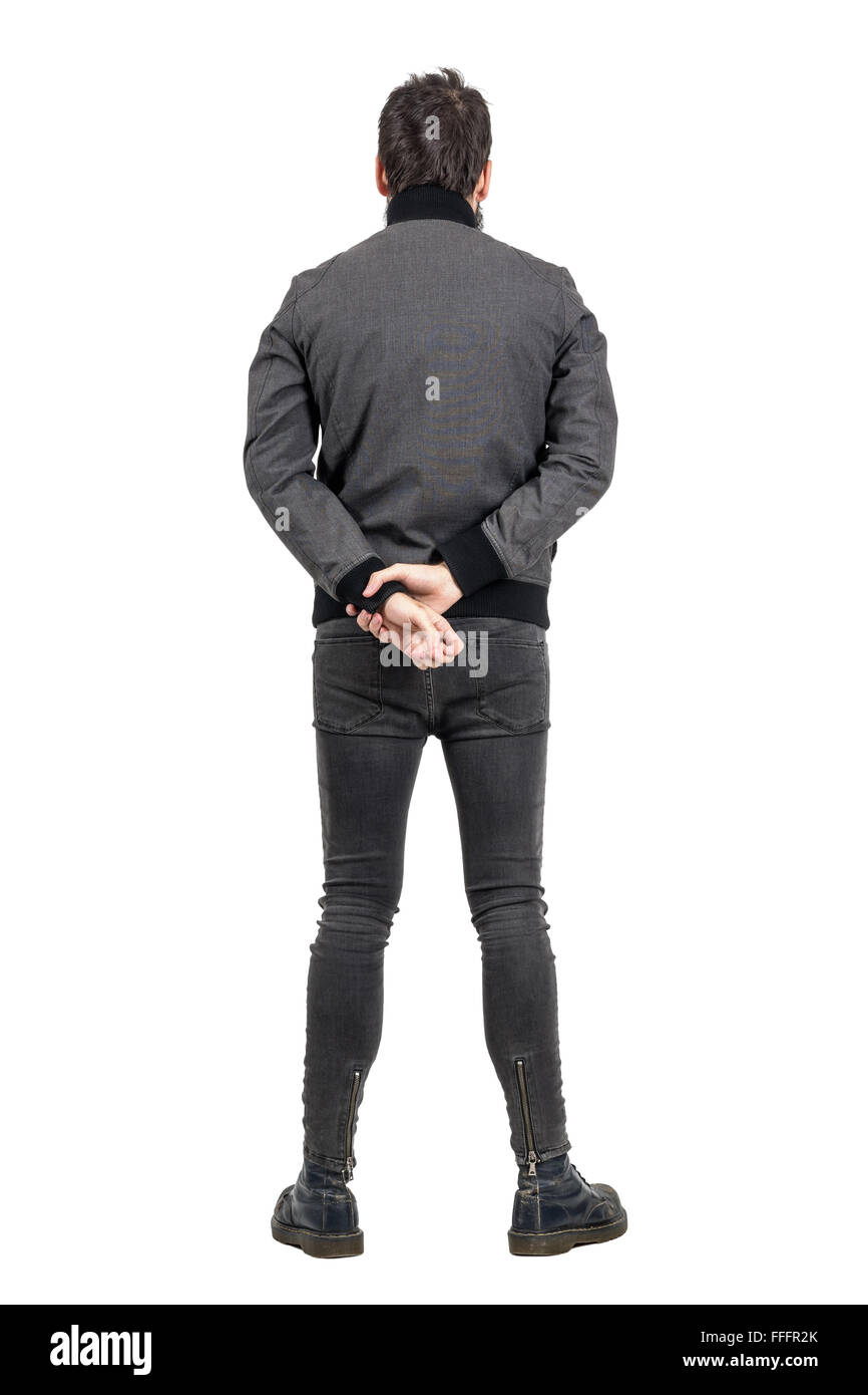 Rear back view of man in tight jeans and gray jacket looking away. Full ...