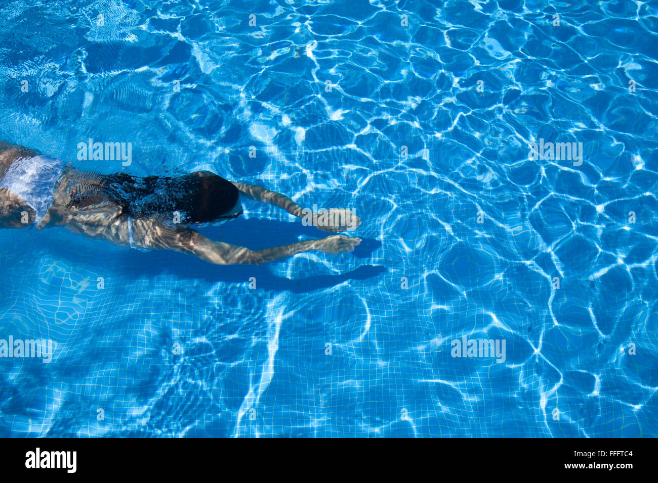 woman with white bikini swimming at the bottom of a blue pool Stock ...