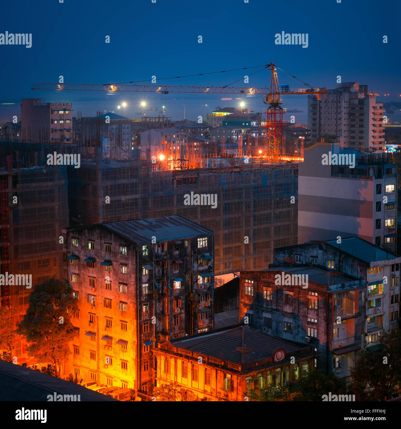 Sunset aerial view of Yangon cityscape with construction cranes ...