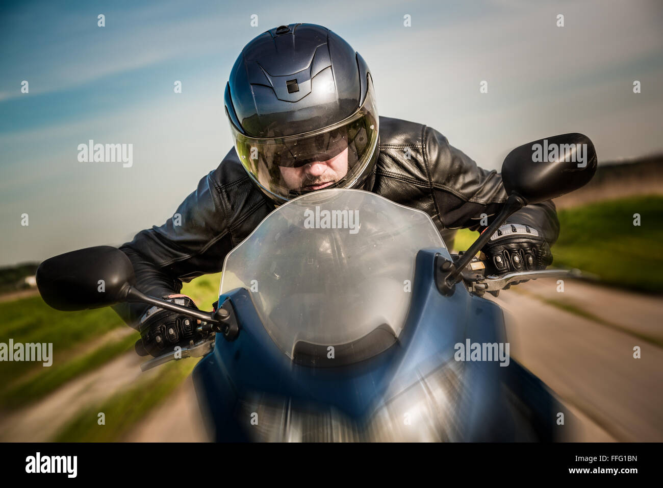 Biker in helmet and leather jacket racing on the road Stock Photo - Alamy