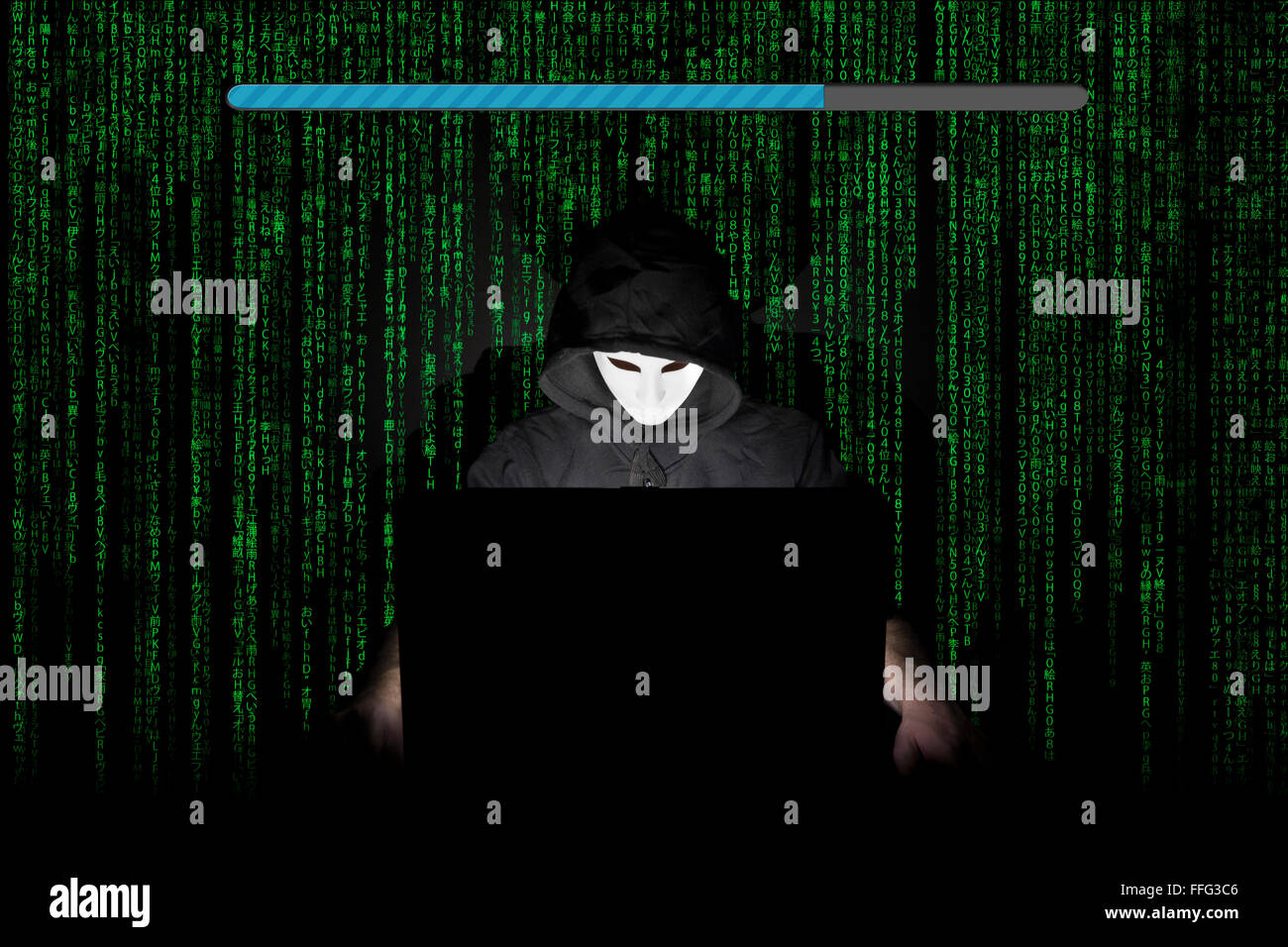 A masked man at a laptop symbolising the dangers of the Internet Stock ...