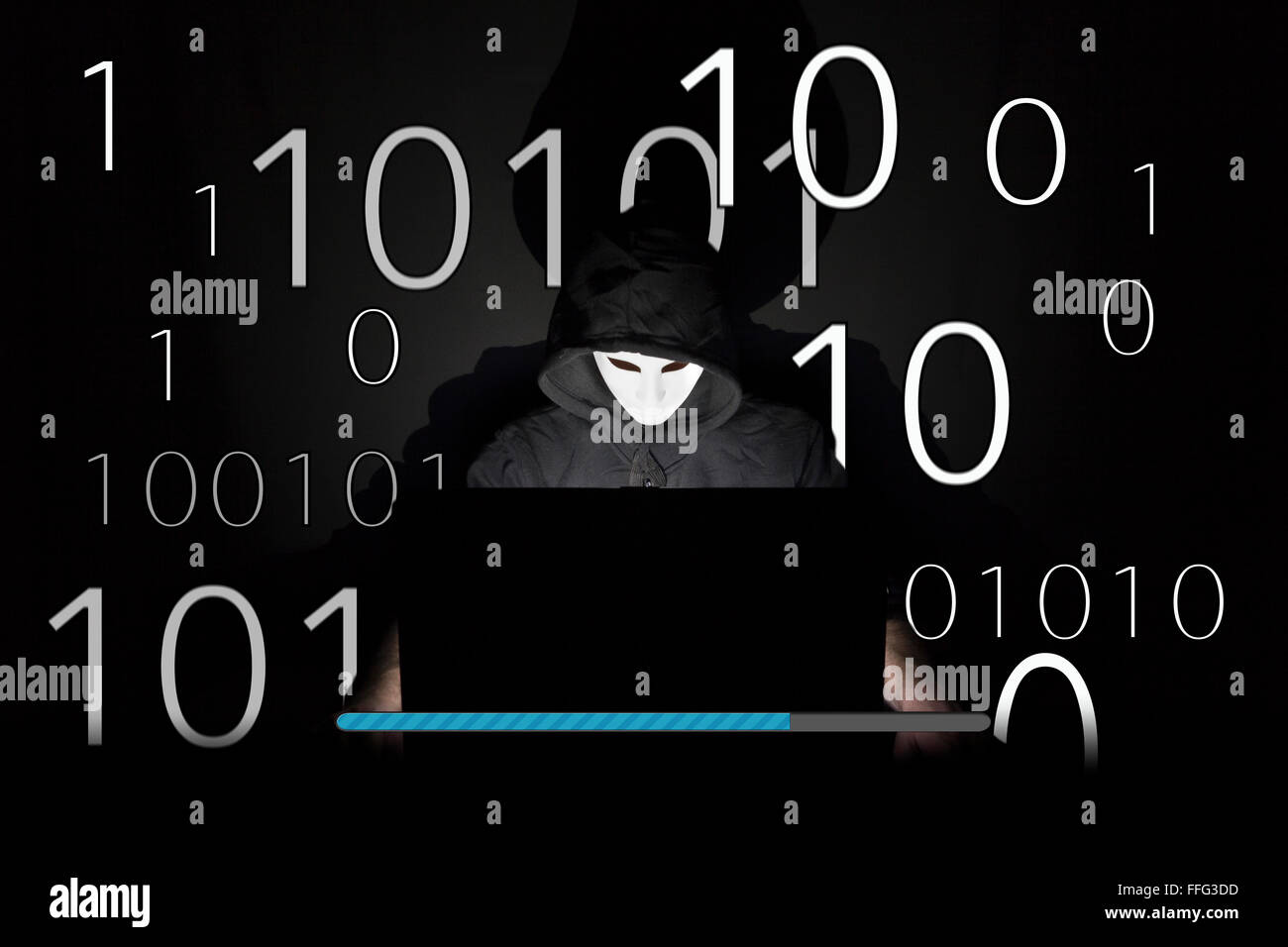 A masked man at a laptop symbolising the dangers of the Internet Stock ...