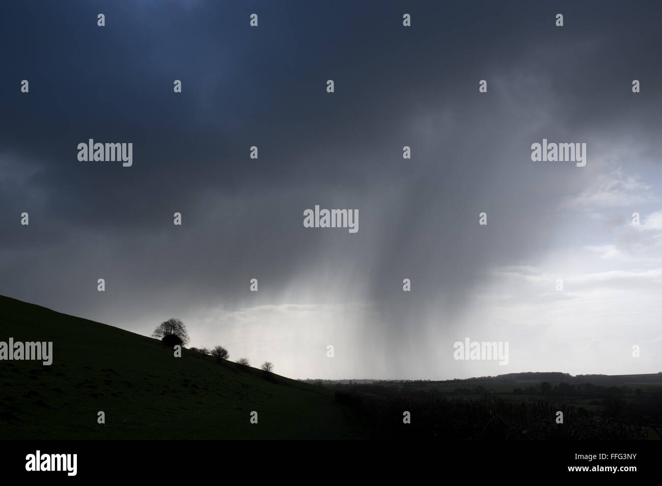 Falling rain from a dark sky with a dark foreground Stock Photo - Alamy