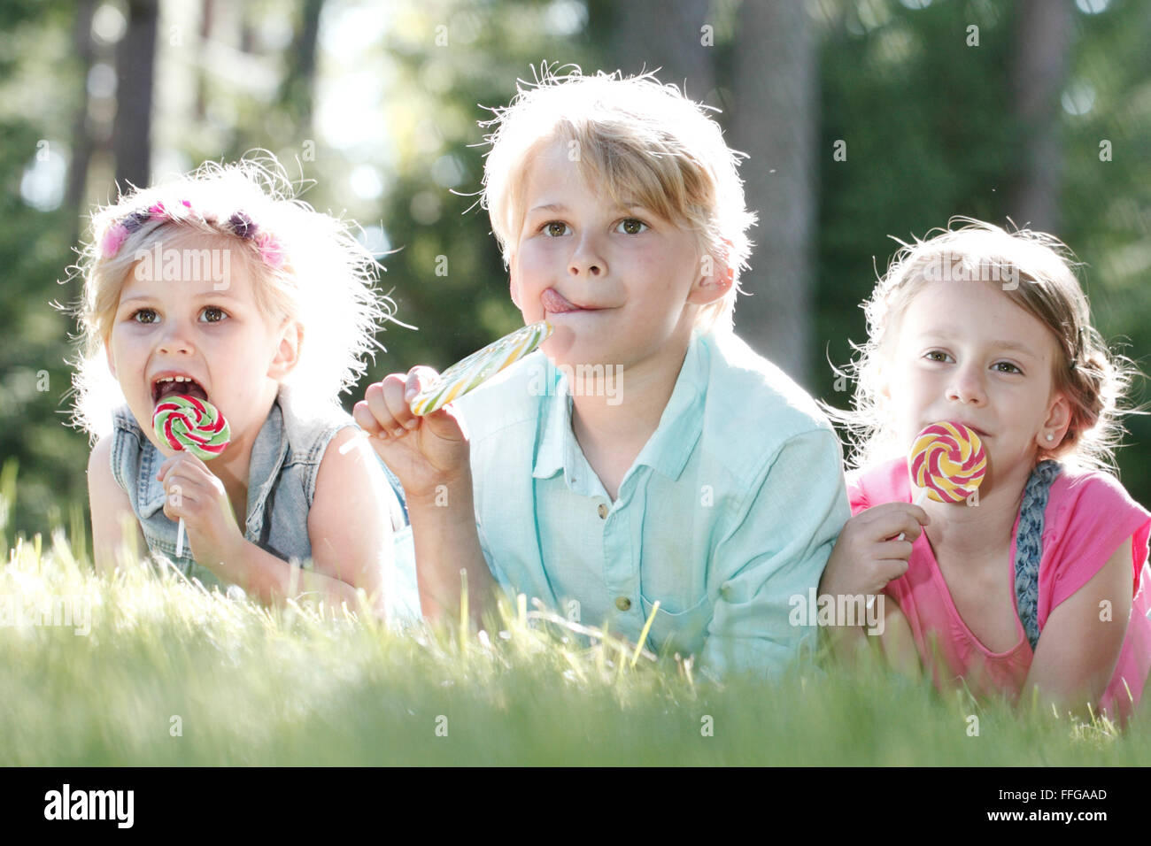 Group of happy children eating lollipops outdoors in summer park Stock ...