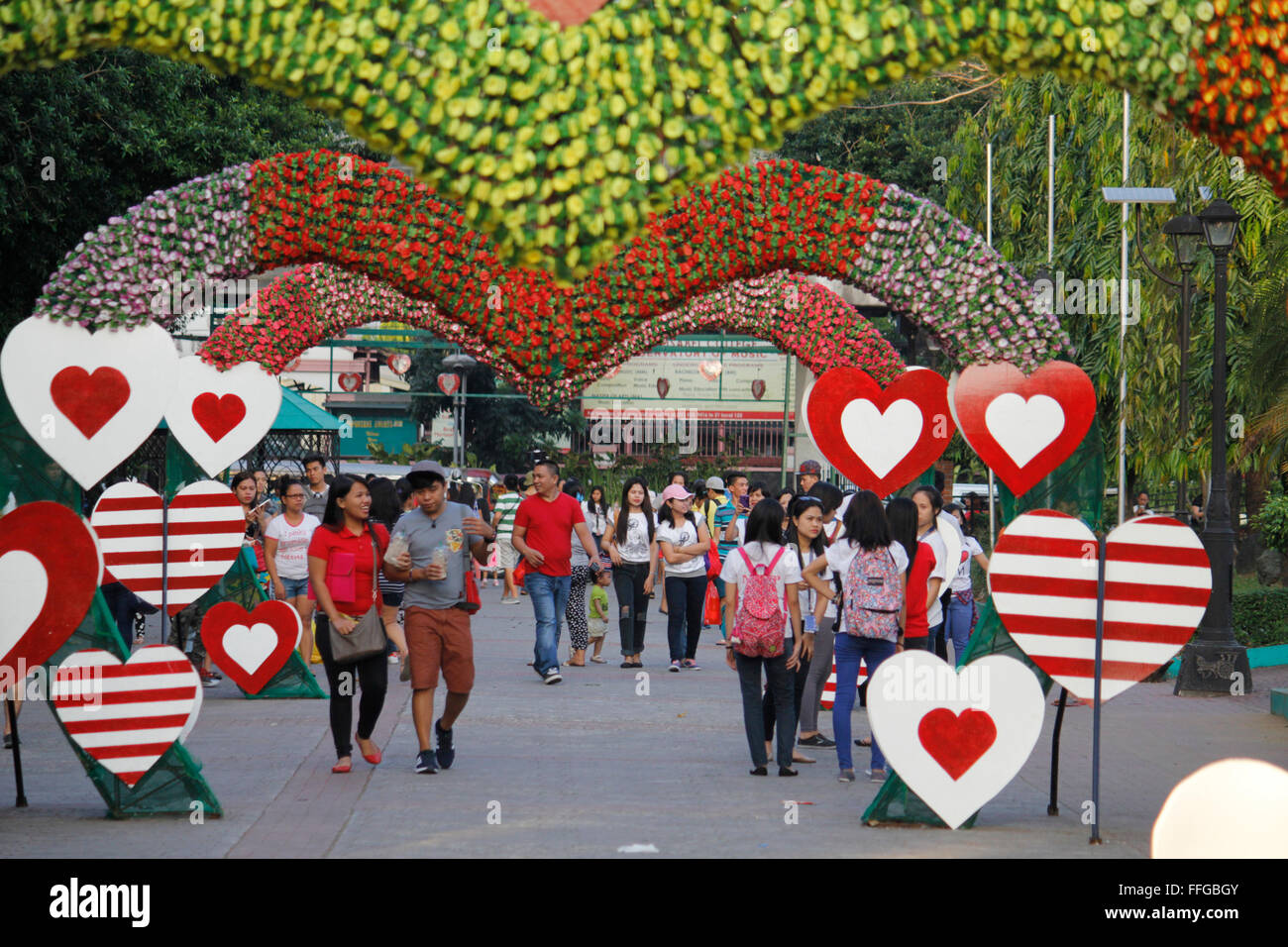 Manila, Philippines. 13th Feb, 2016. People walk past heart shaped arcs ...