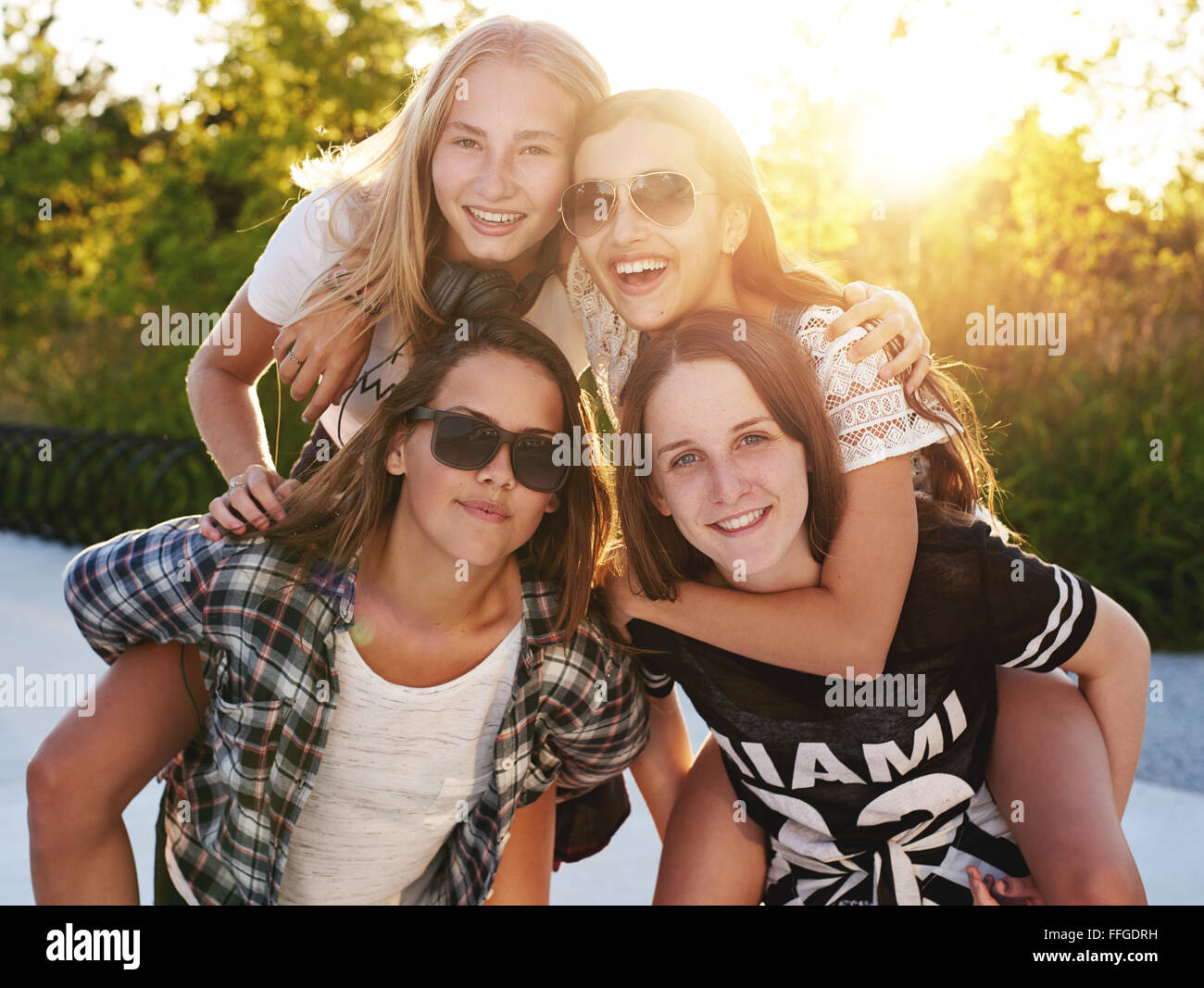 Portrait of best friends riding piggyback outside in a park Stock Photo ...