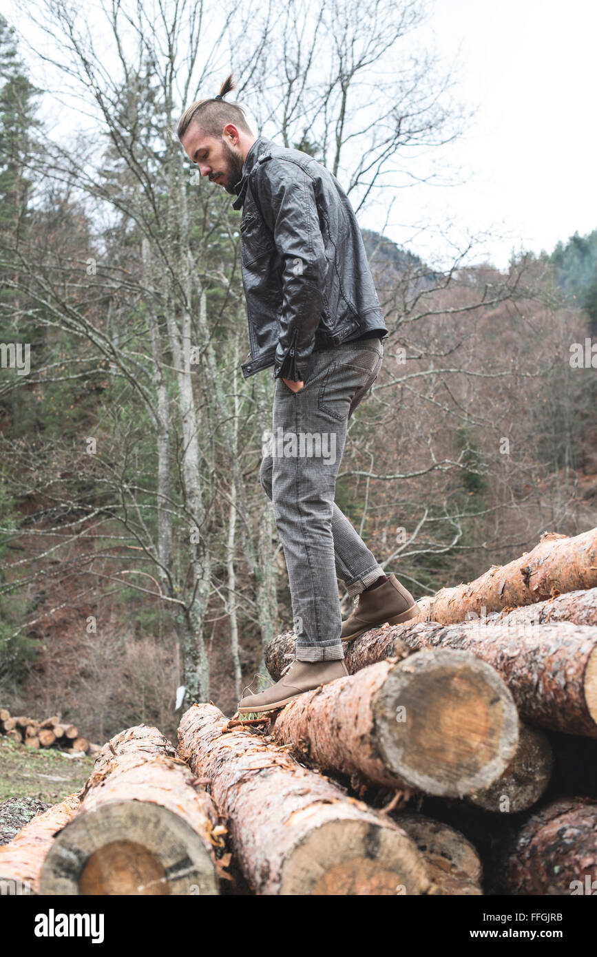 Young men on logs in the forest. Leather and jeans Stock Photo - Alamy