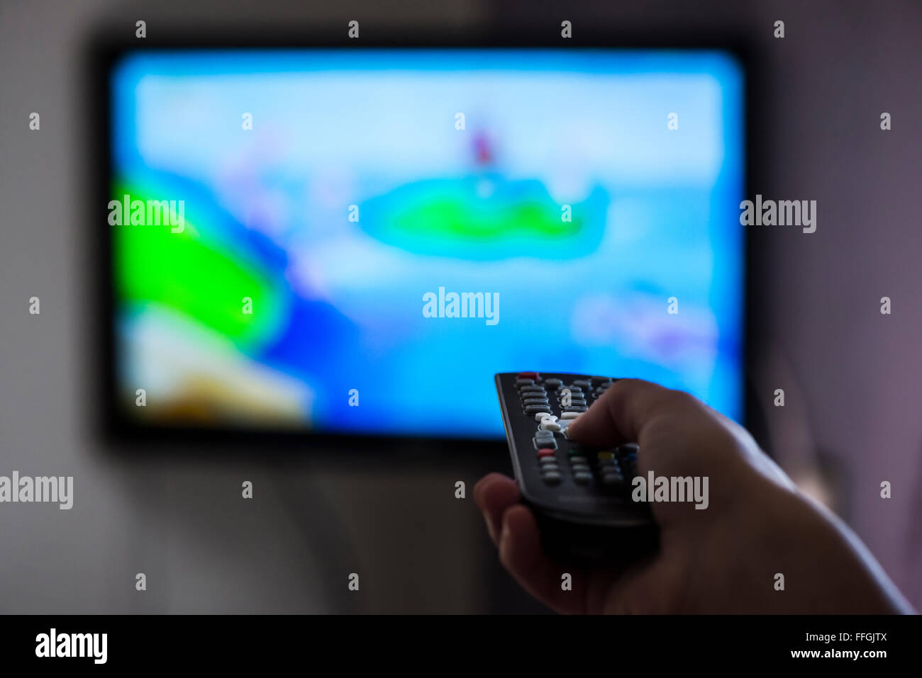 TV and remote control. Hand hold remote Stock Photo - Alamy